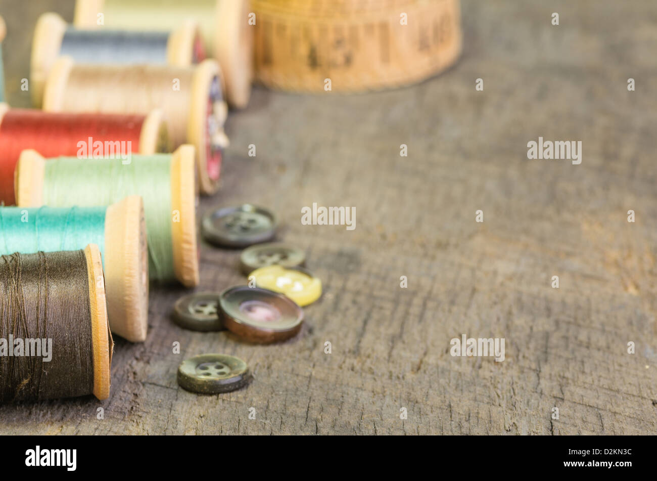 A row of sewing thread spools with buttons Stock Photo - Alamy