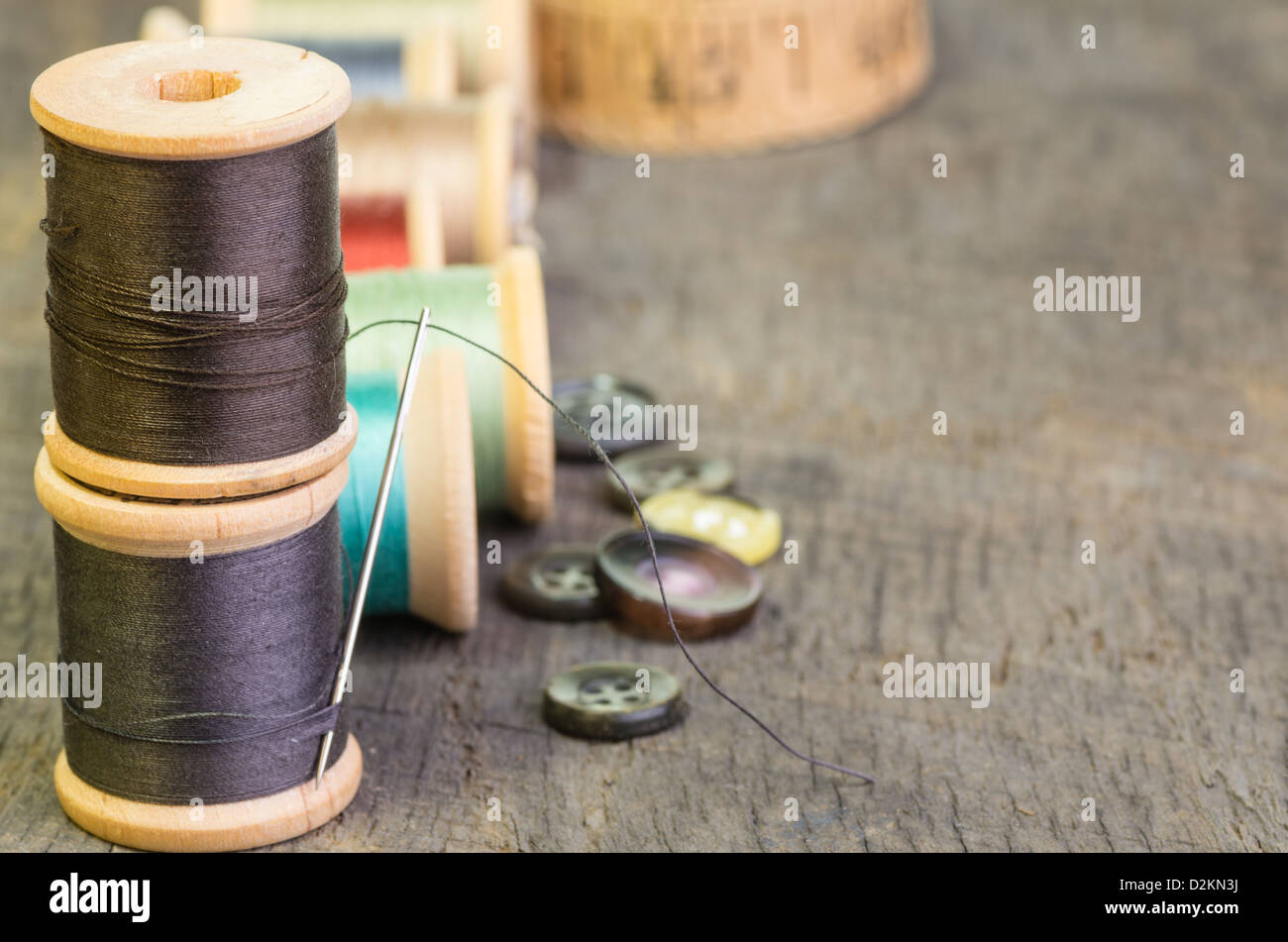 A stack of sewing thread spools with needle and buttons Stock Photo - Alamy
