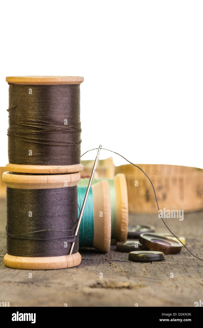 Stack of sewing thread with needle and buttons Stock Photo - Alamy