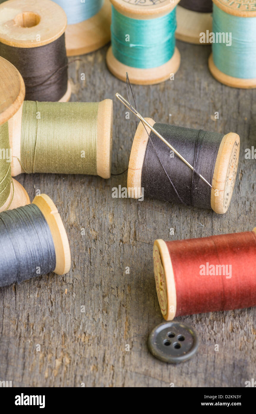 Spools of sewing thread on table with a needle Stock Photo - Alamy