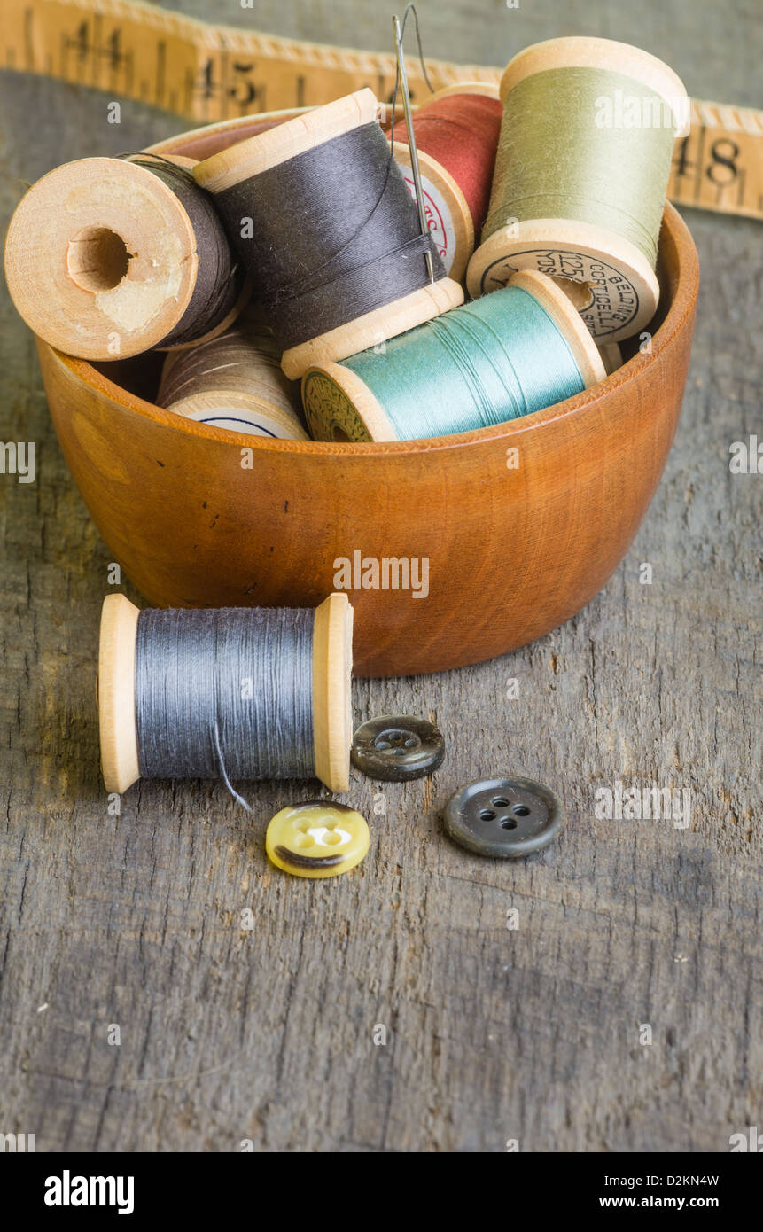 Wooden bowl with spools of thread and buttons Stock Photo - Alamy