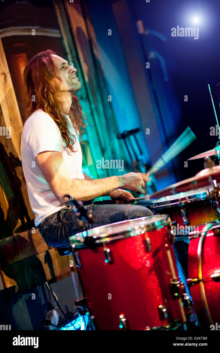 musician playing drums on a red background Stock Photo - Alamy