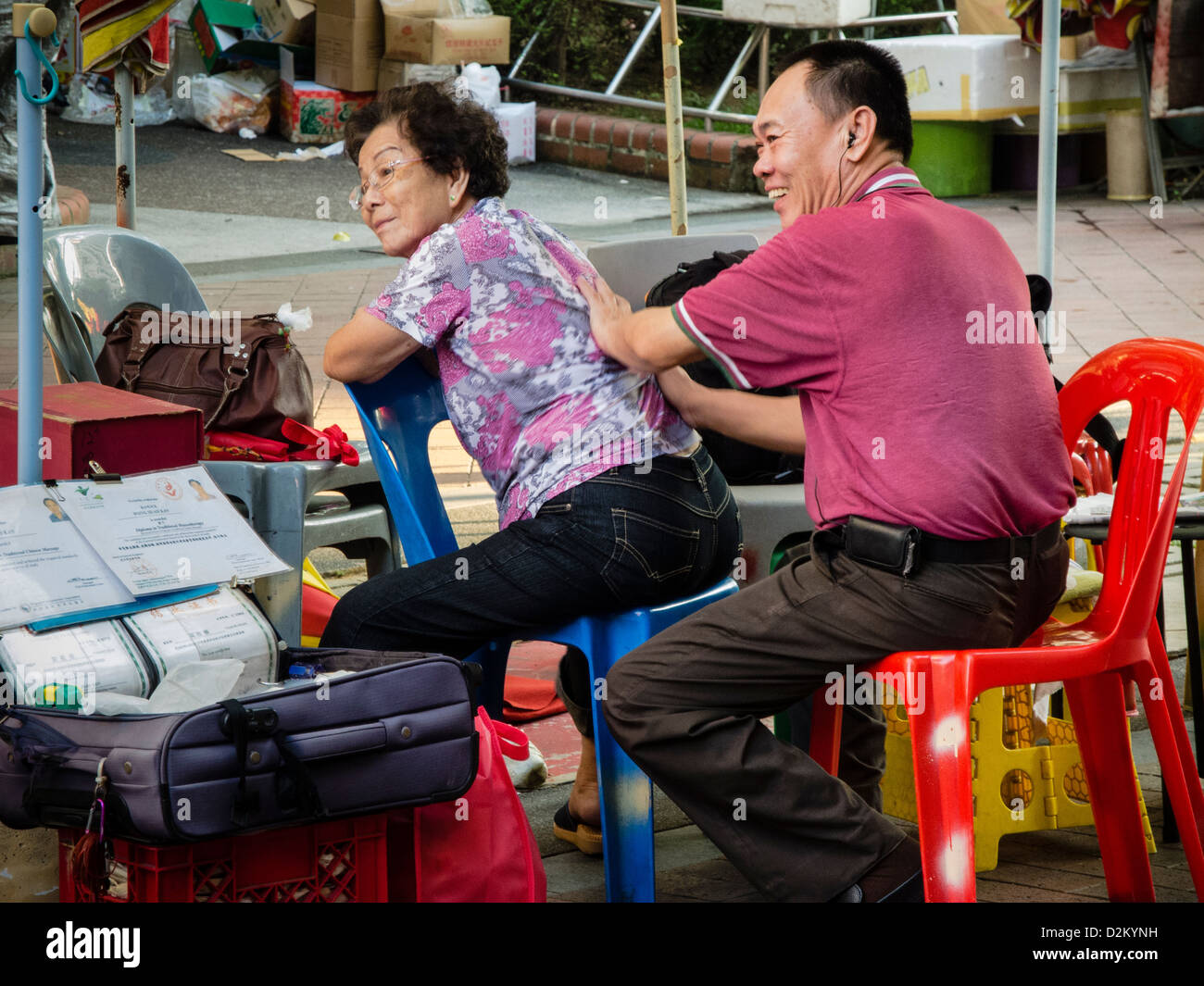Man gives massage service in the street in front of a temple Stock ...