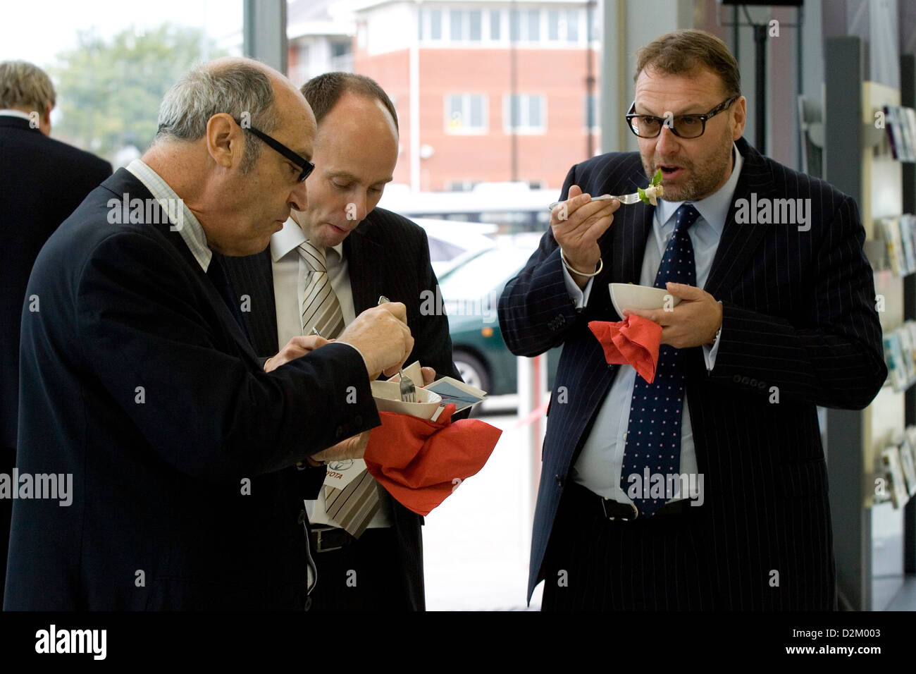 Men in suits stand and eat from bowls hi-res stock photography and ...