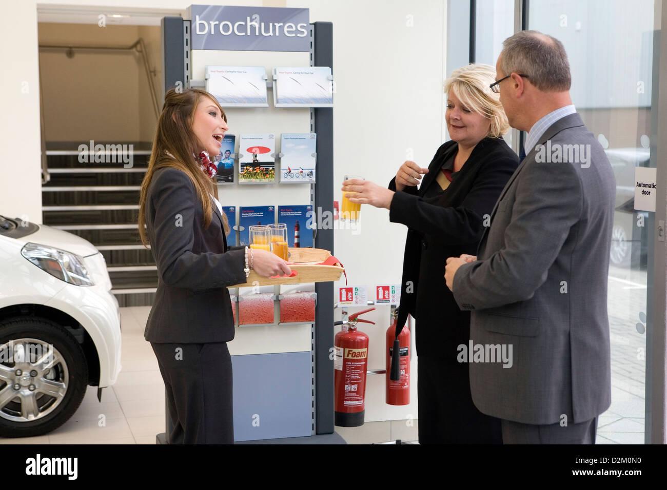 Customers receive complementary drinks in a newly built car dealership ...