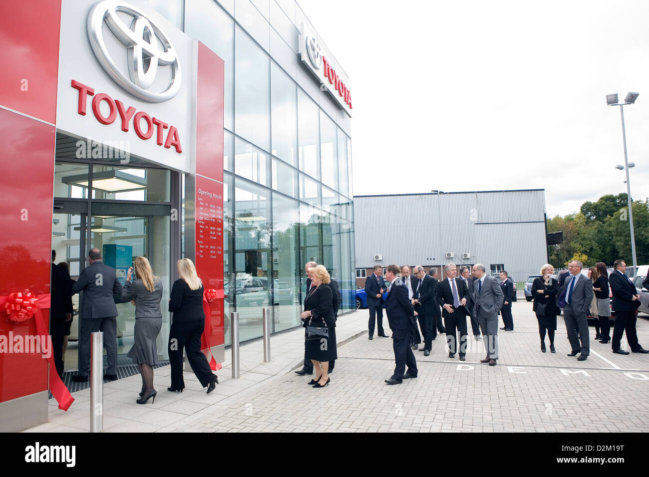 A large group of people wait to enter a Toyota car dealership in the UK ...
