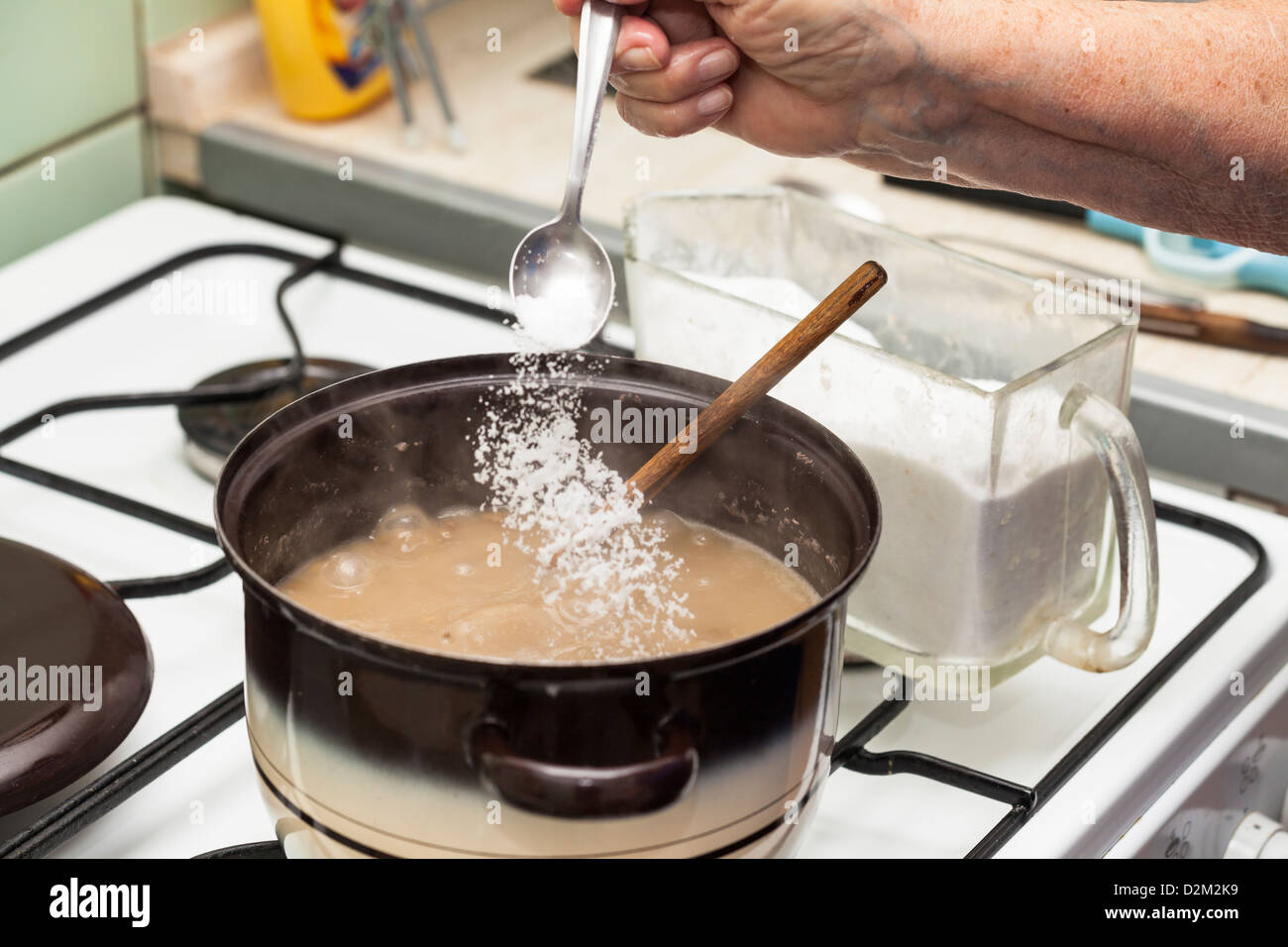 Detail of pouring salt into boiling soup in pot on cooker Stock Photo ...