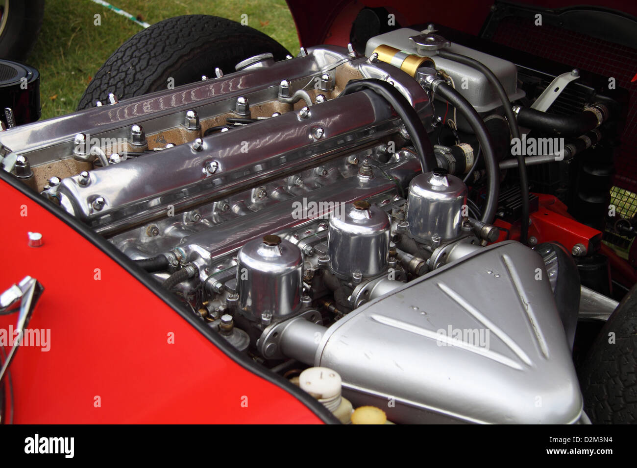 A view of the engine of a red E-type Jaguar on display at a classic car ...