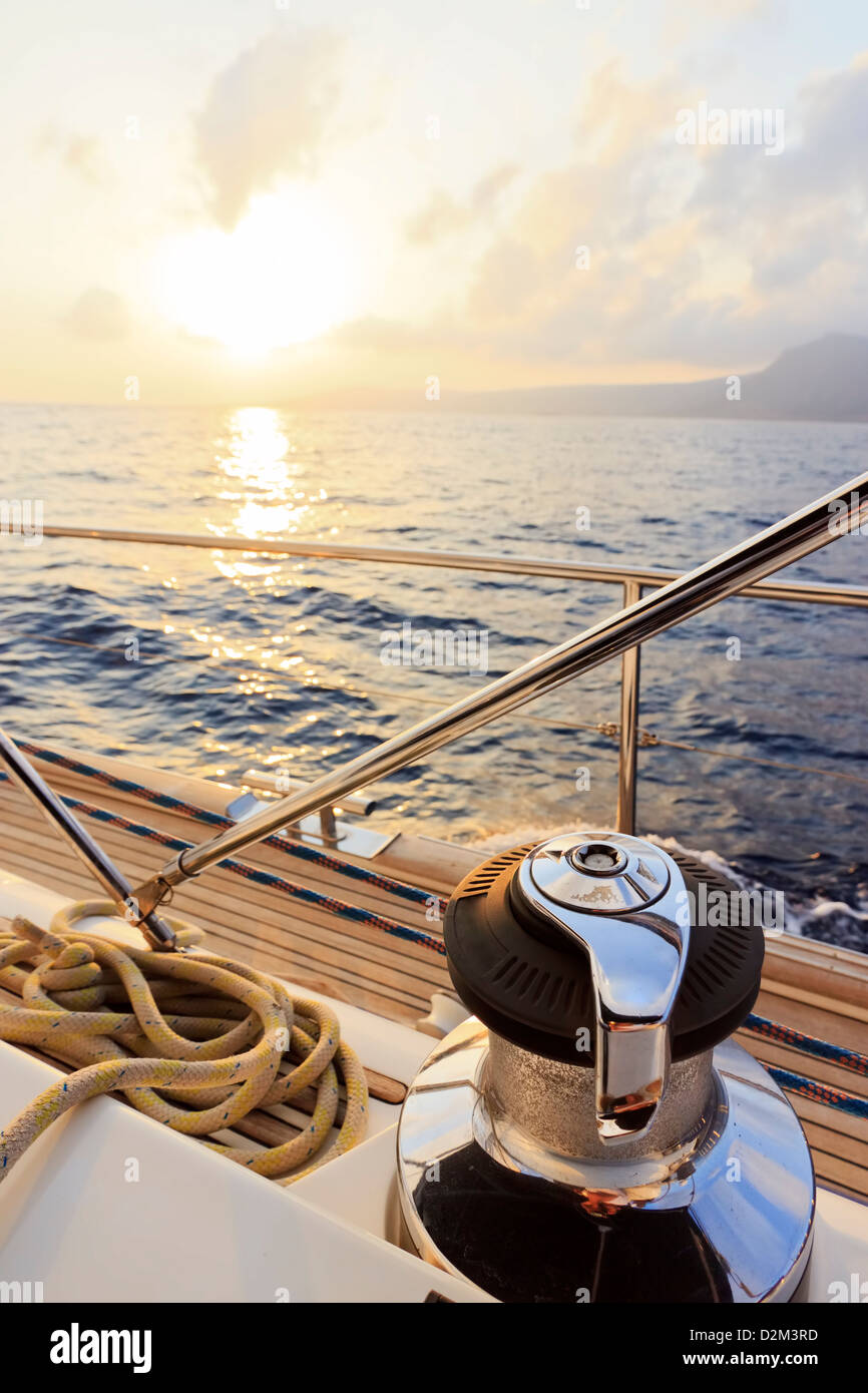 Yacht sailing along the coast at sunset Stock Photo - Alamy