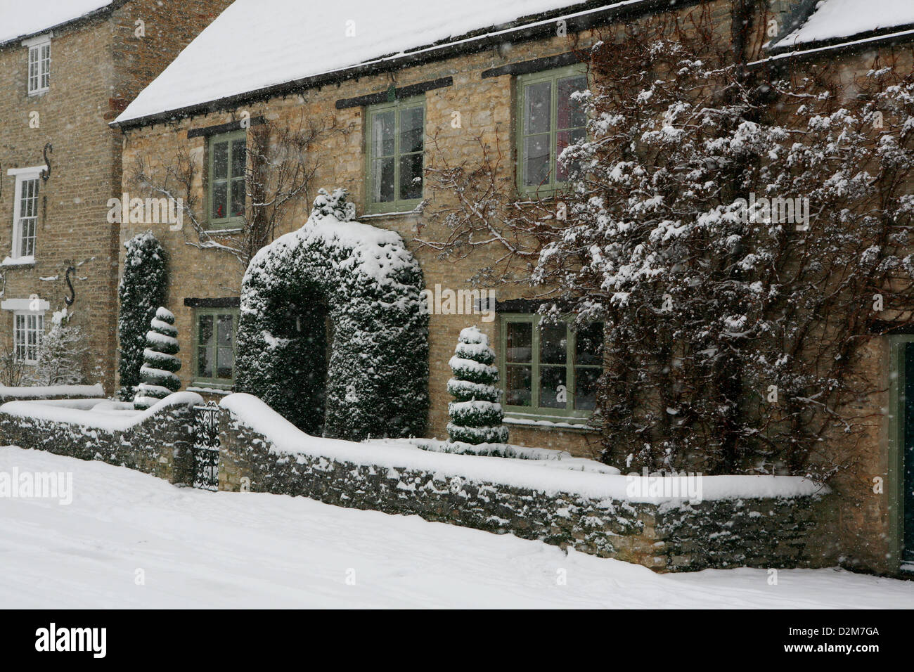 English cottage in winter time and it is snowing, the building and it's ...
