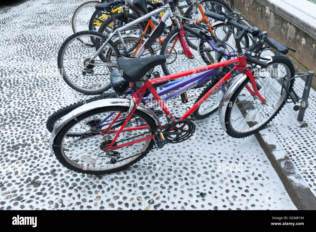 Cycles parked on cobbles in Cambridge UK in the snow Stock Photo - Alamy