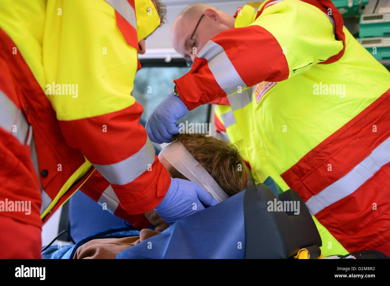 The illustration shows paramedics administering medical treatment to a ...