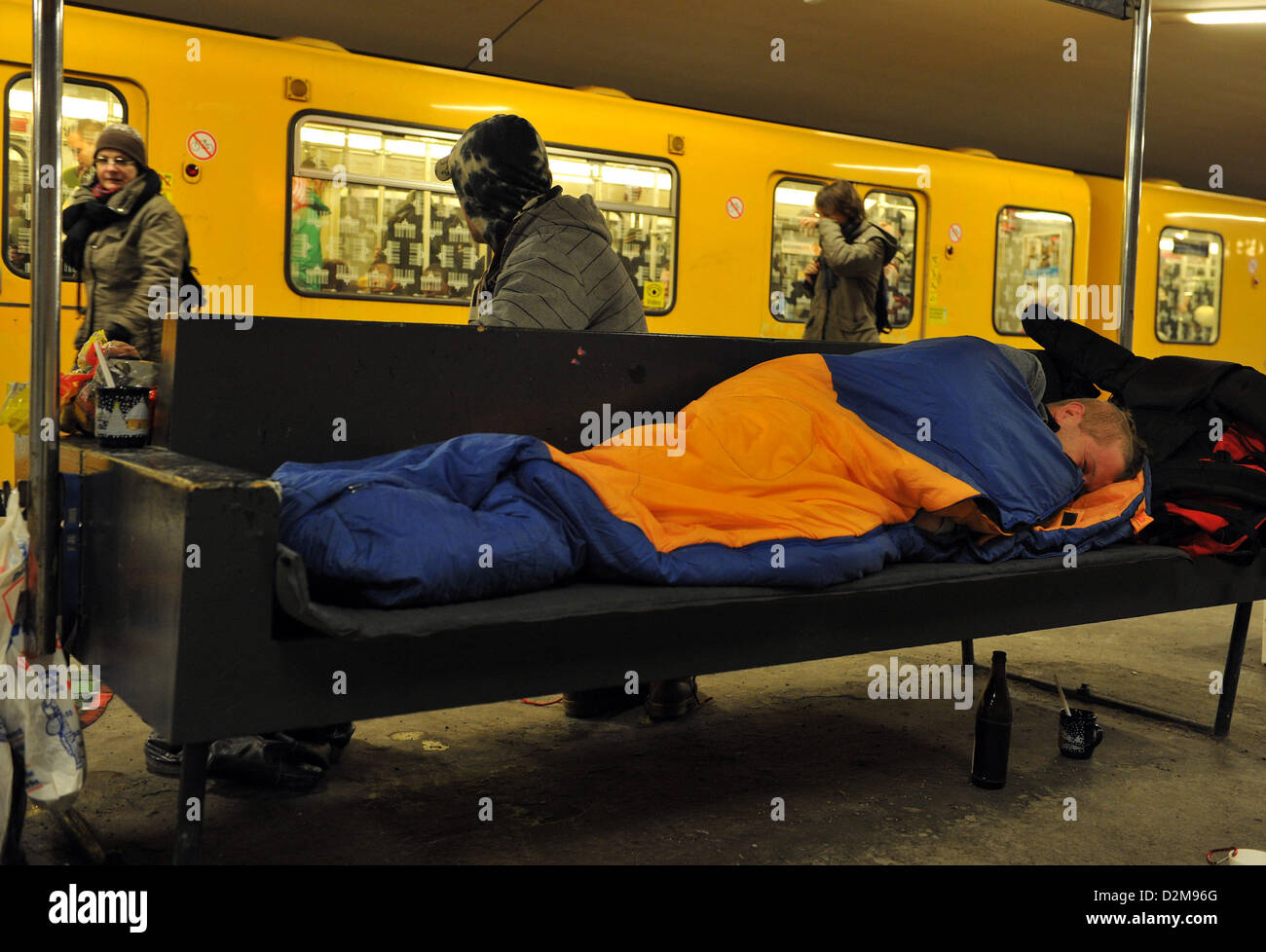 A homeless person rests on a bench in an underground station in Berlin ...