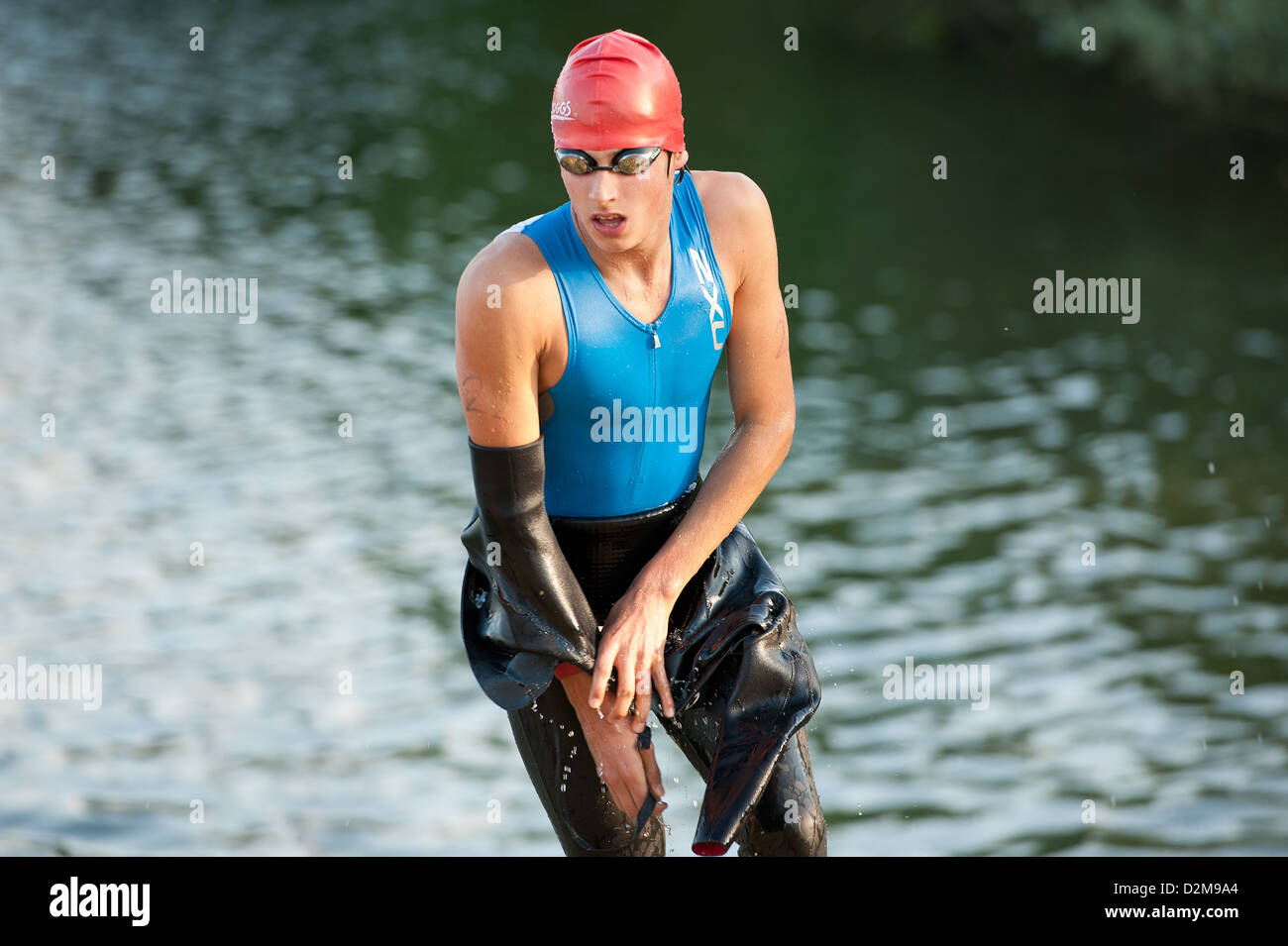 First swimmer out of transition running and taking off wetsuit with ...