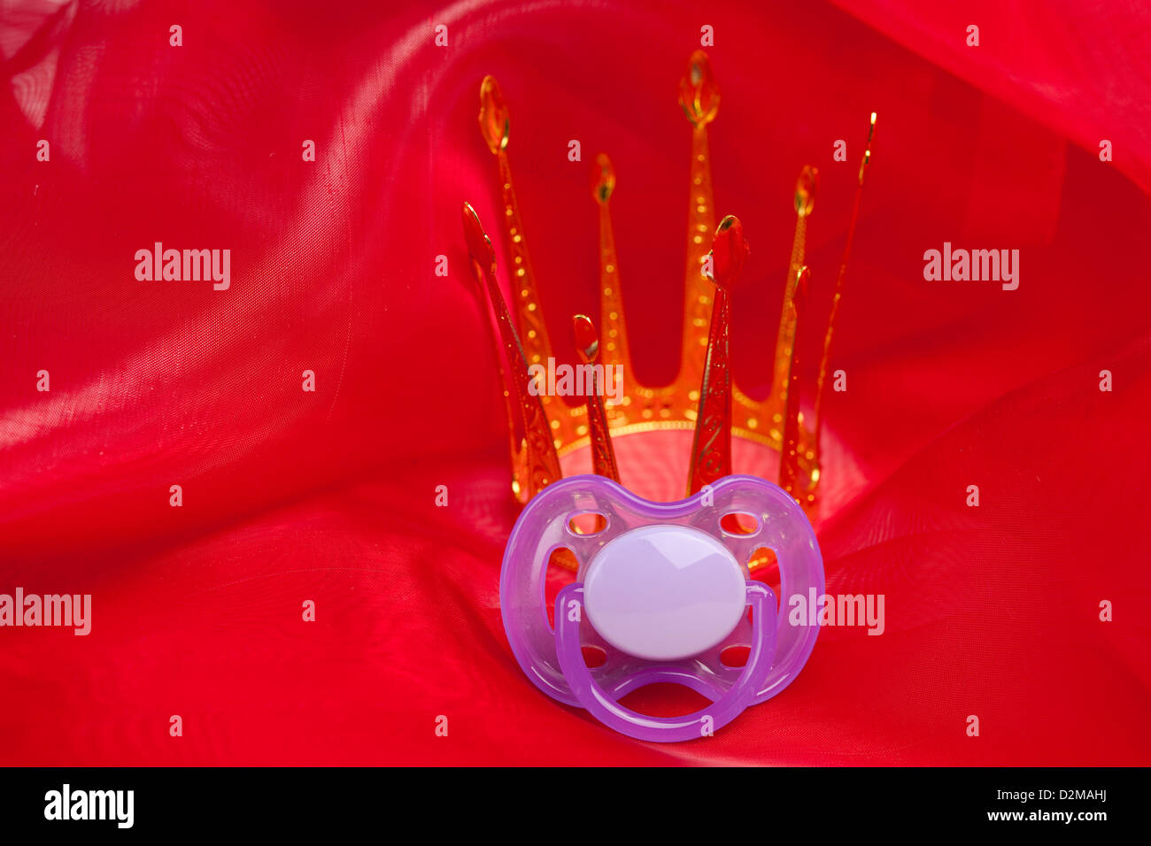 Symbolic picture of a pink pacifier on red background Stock Photo - Alamy