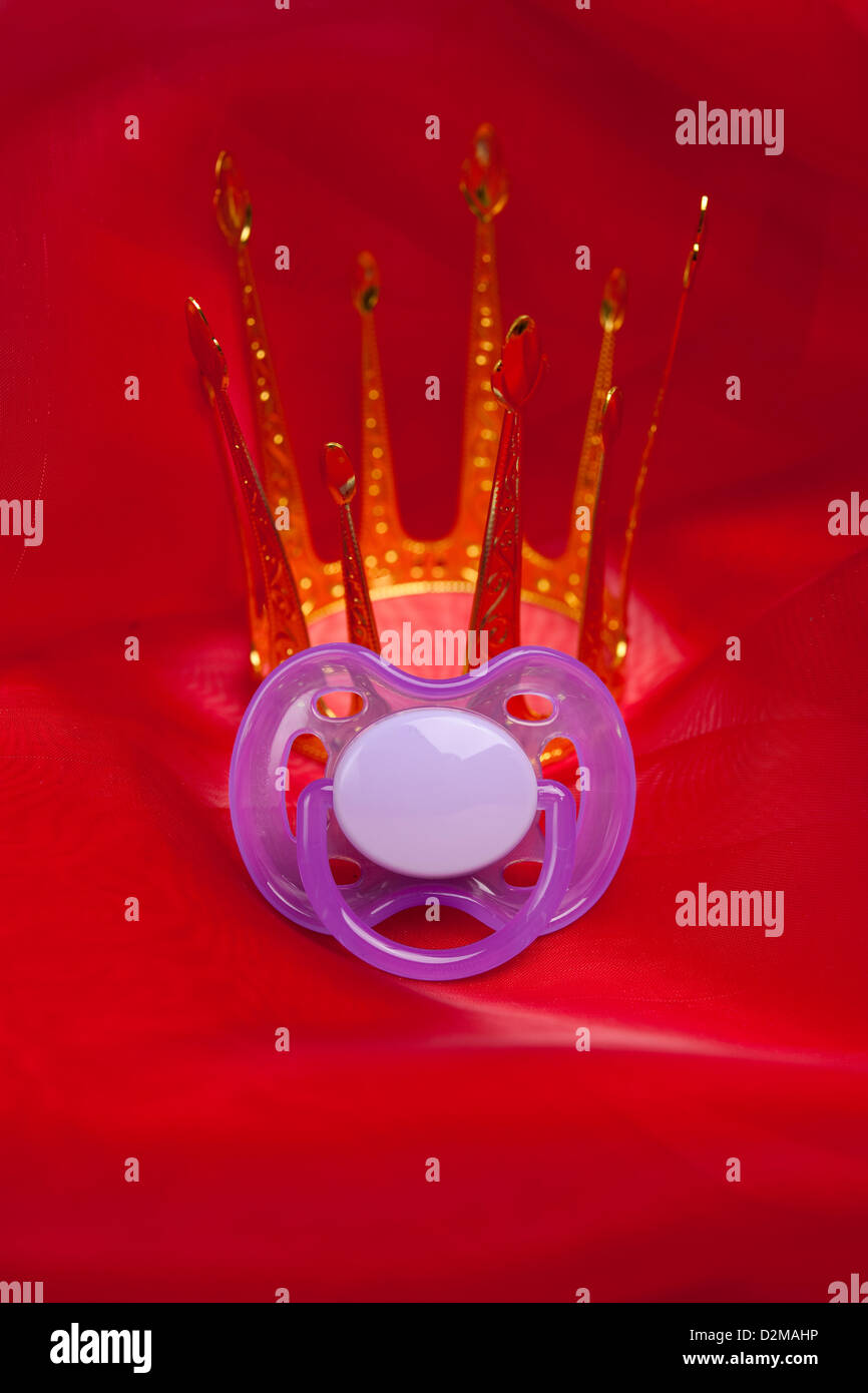 Symbolic picture of a pink pacifier on red background Stock Photo - Alamy