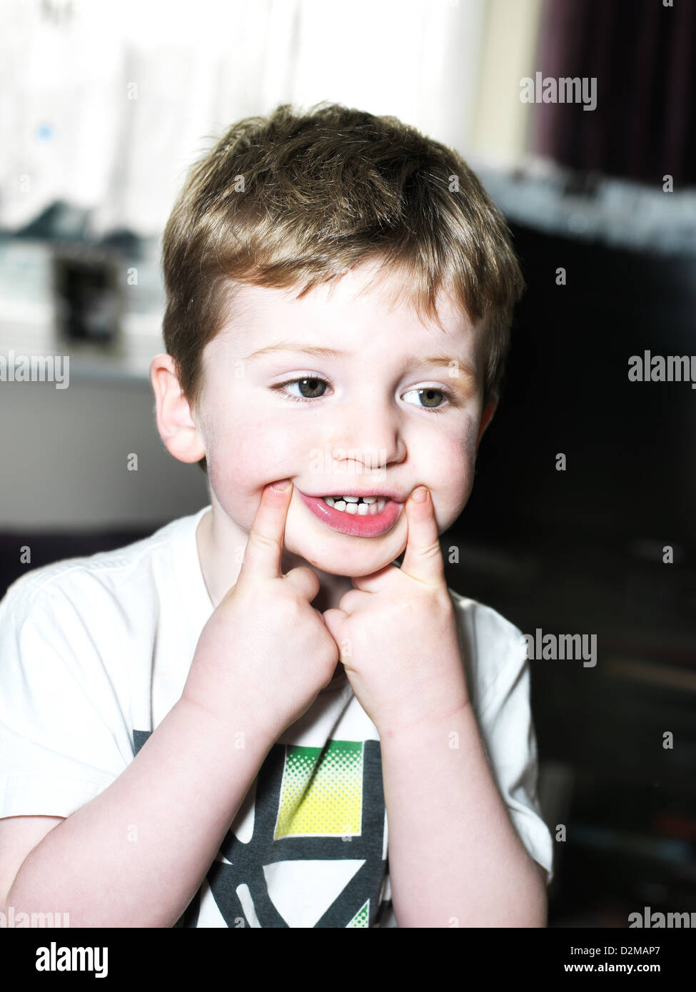 Young boy forcing a smile Stock Photo - Alamy