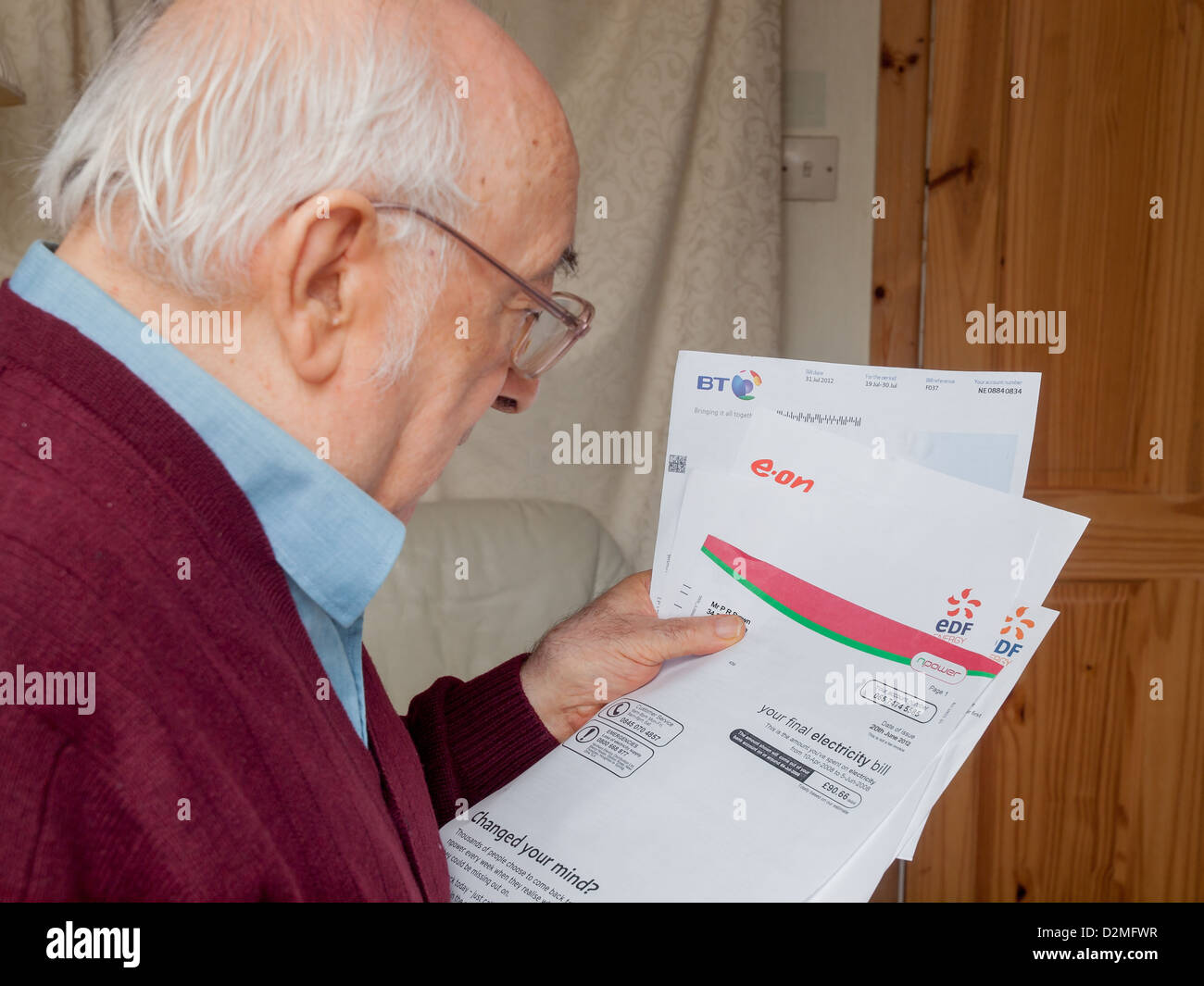 elderly man looking at household utility bills Stock Photo - Alamy