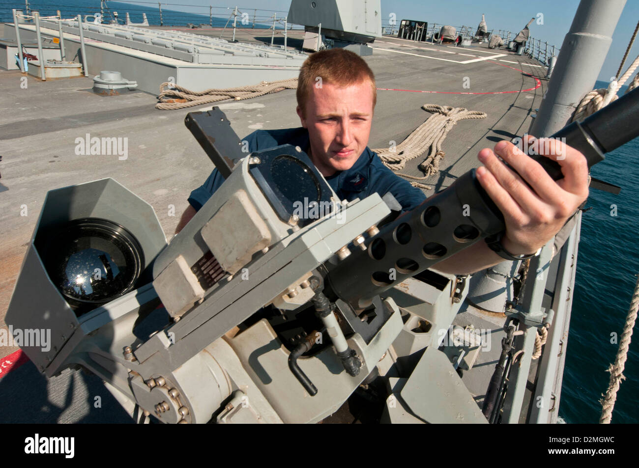 Gunner's Mate 2nd Class Robert N. Reed performs routine maintenance on ...
