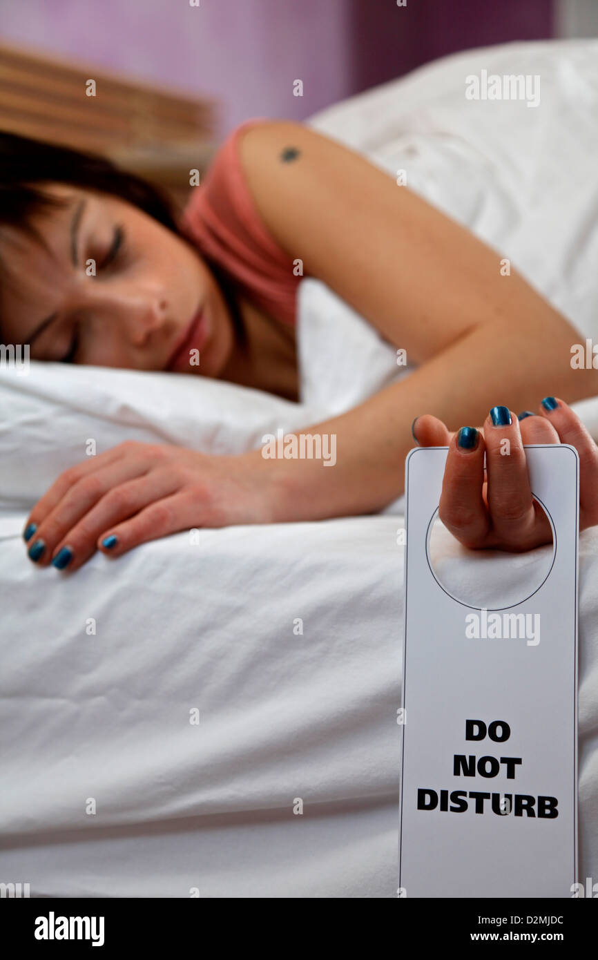 A person sleeping with a "Do not disturb" sign attached [concept] Stock ...