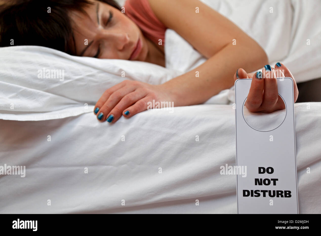 A person sleeping with a "Do not disturb" sign attached [concept] Stock ...