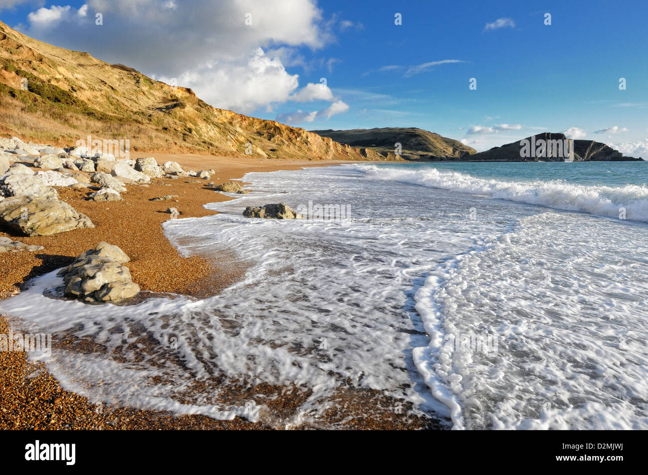 Waves roll up the beach at Worbarrow Bay, Dorset on a crisp winters ...