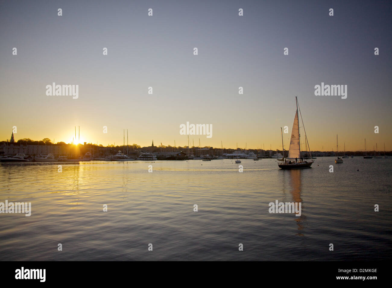 Serene sunset sailing in Rhode Island, capturing a sailboat gliding ...