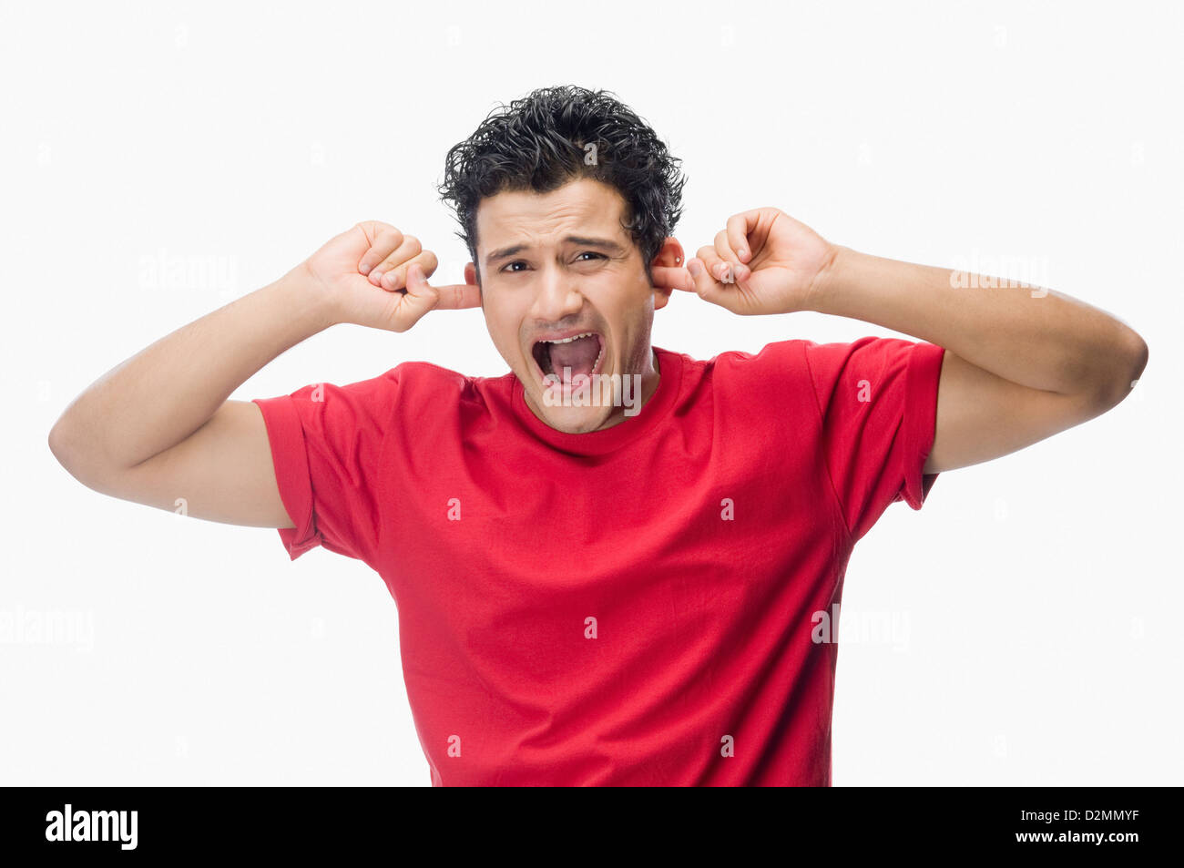 Portrait of a man screaming with his fingers in ears Stock Photo - Alamy