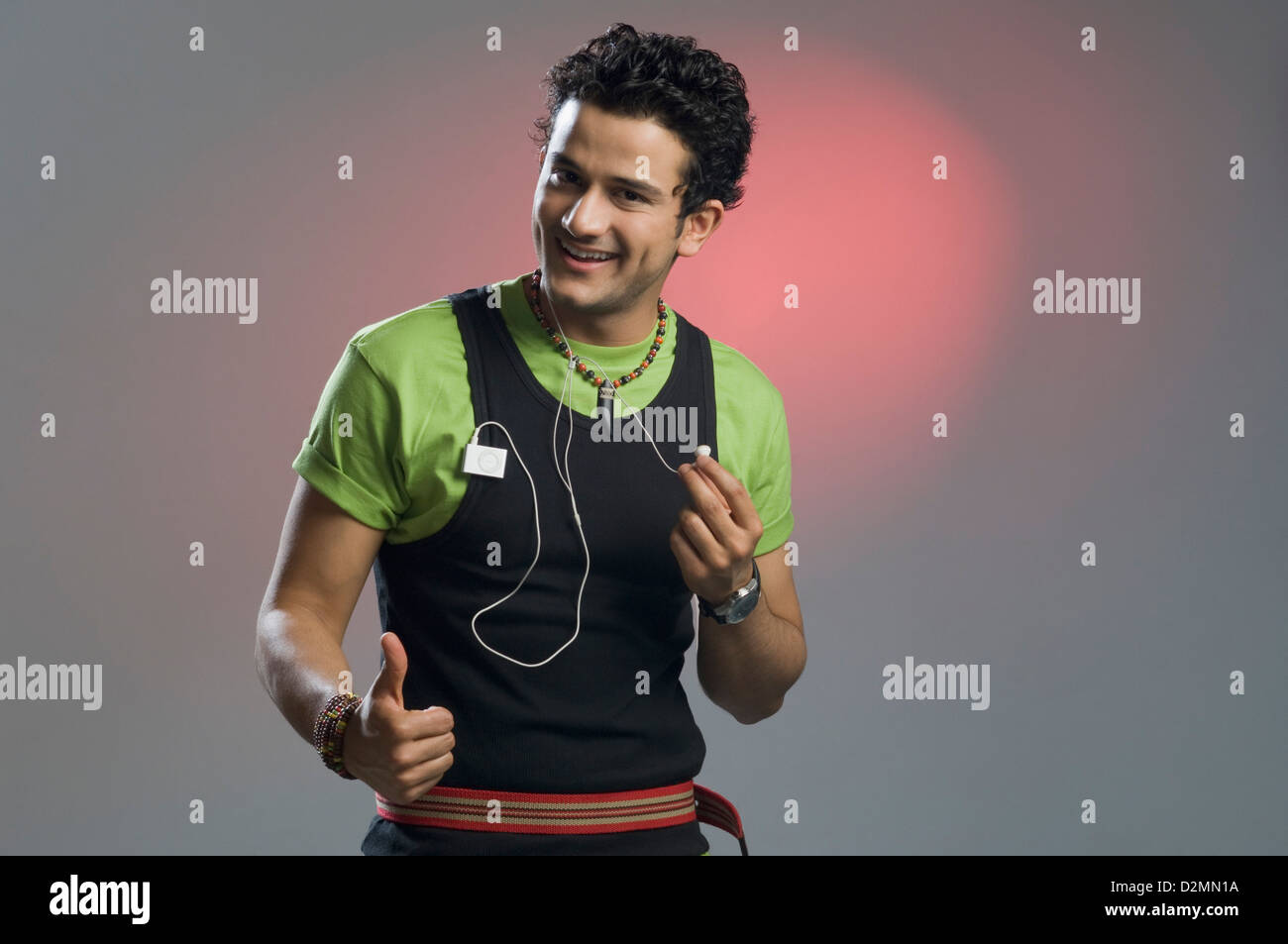 Man listening to music and showing thumbs up sign Stock Photo - Alamy