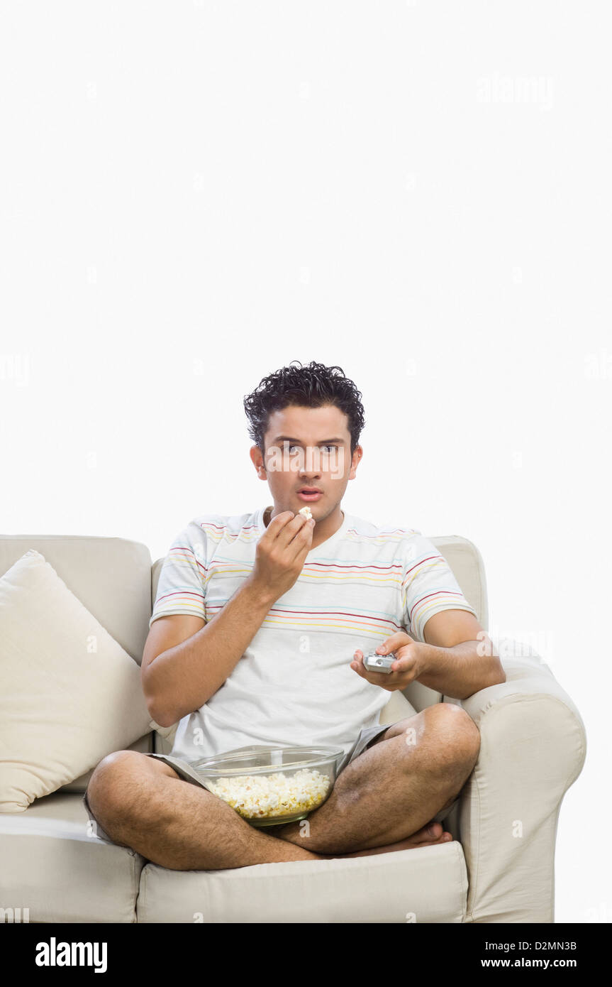 Man watching television and looking surprised Stock Photo - Alamy