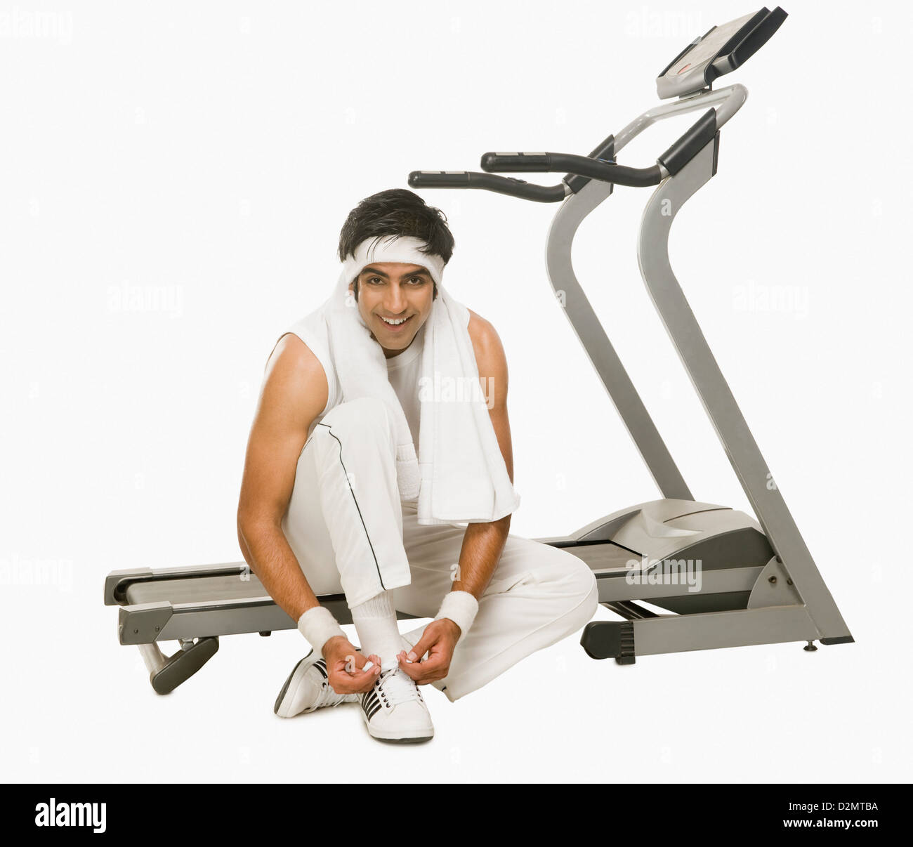 Man sitting on a treadmill and tying shoelaces Stock Photo - Alamy