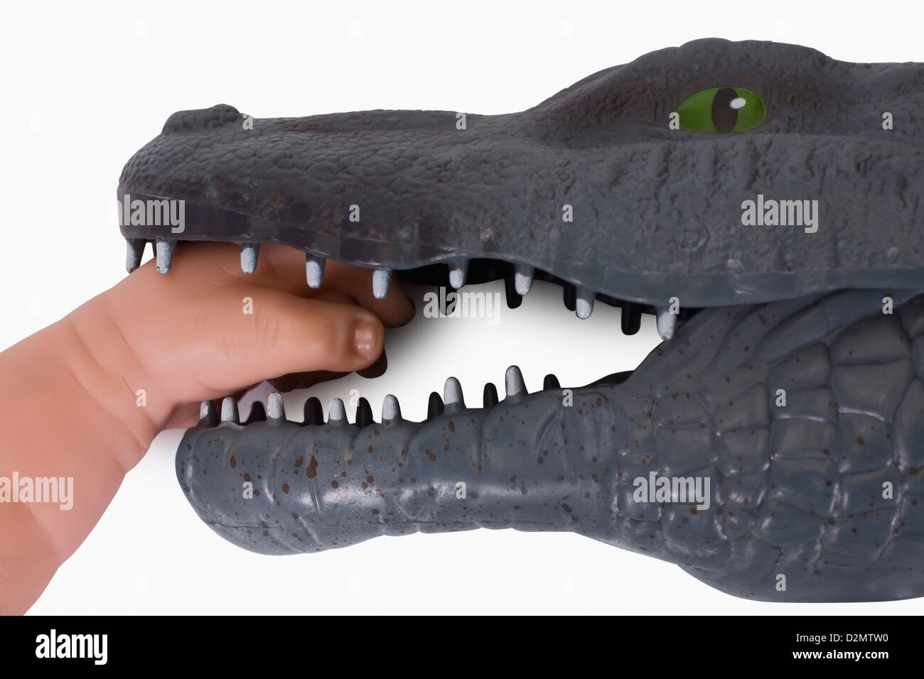 Toy crocodile holding a doll's hand in jaw Stock Photo - Alamy
