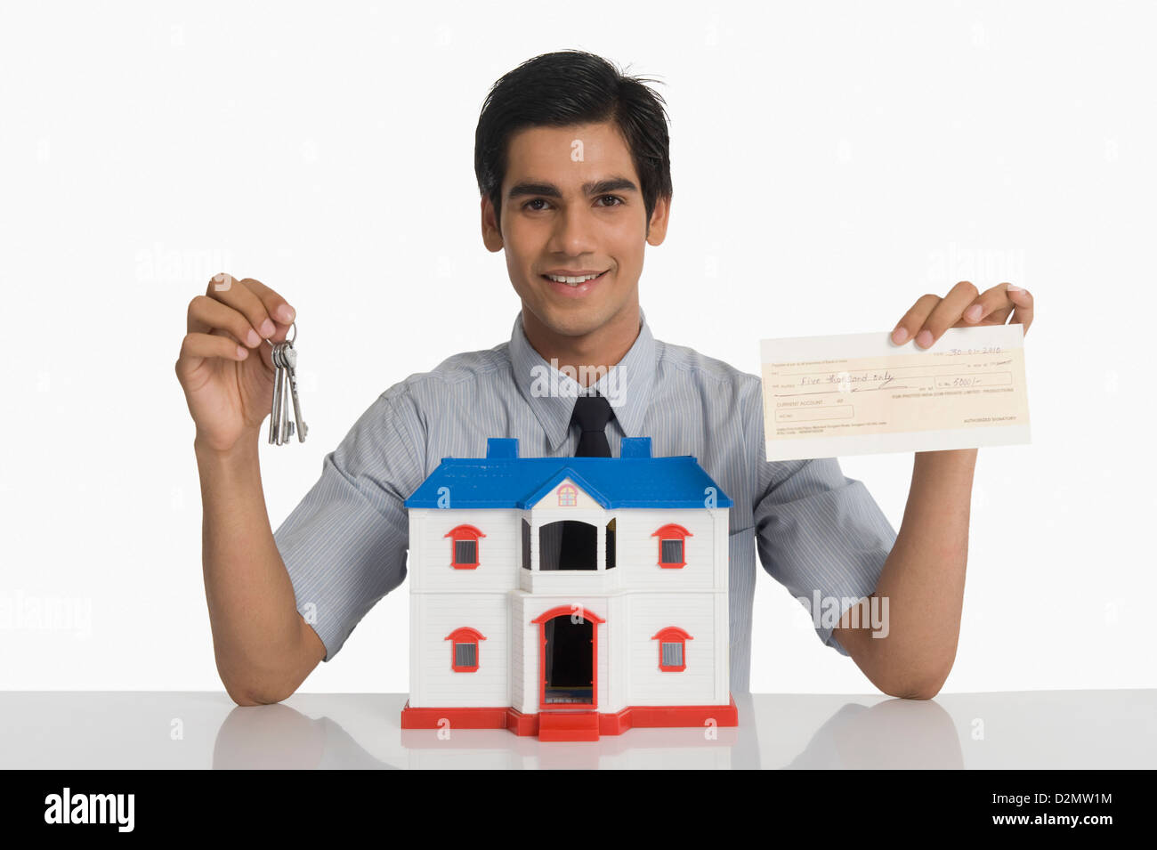 Real estate agent showing keys and a check near a model home Stock ...