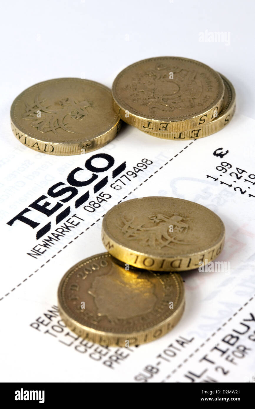 A Tesco supermarket receipt and pound coins to illustrate the concept ...