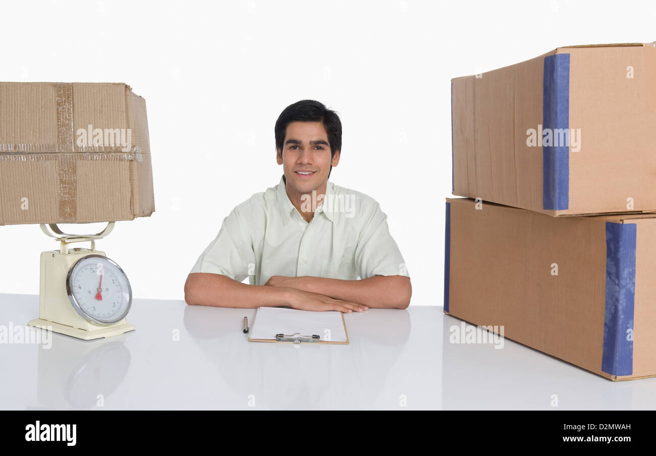 Store incharge at desk with a weight scale and cardboard boxes Stock ...