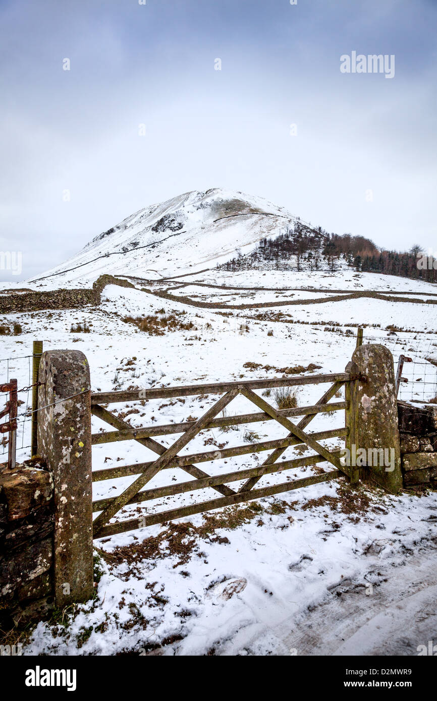 Wintery countryside view up the snowy fell through traditional farm ...