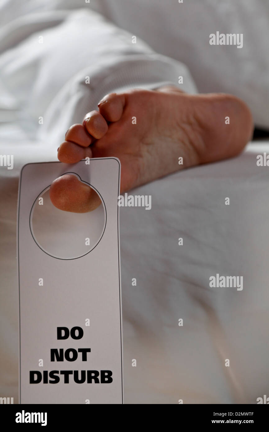A person sleeping with a "Do not disturb" sign attached [concept] Stock ...