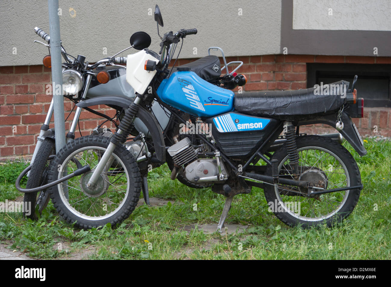 Two motorcycles of the brand Simson are secured to a pole in Stralsund ...