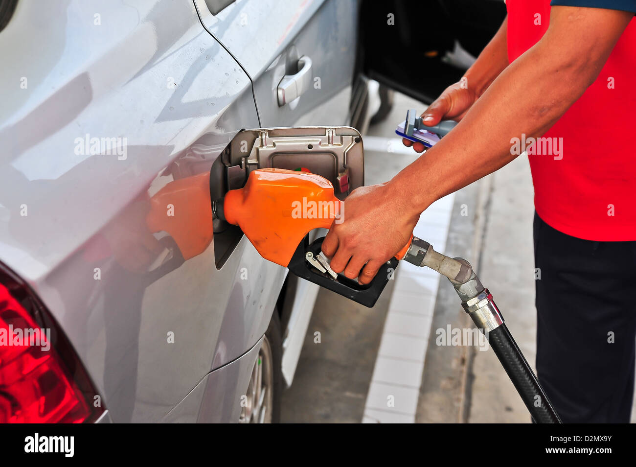 Man's hand holding a gas pump Stock Photo - Alamy