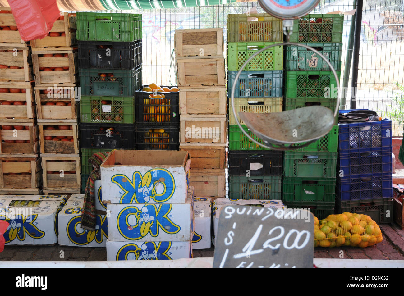 crates, boxes stacked together with weighing scales in street market ...