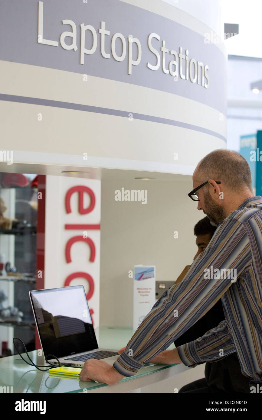 Two men standing at a laptop station in a car garage Stock Photo - Alamy