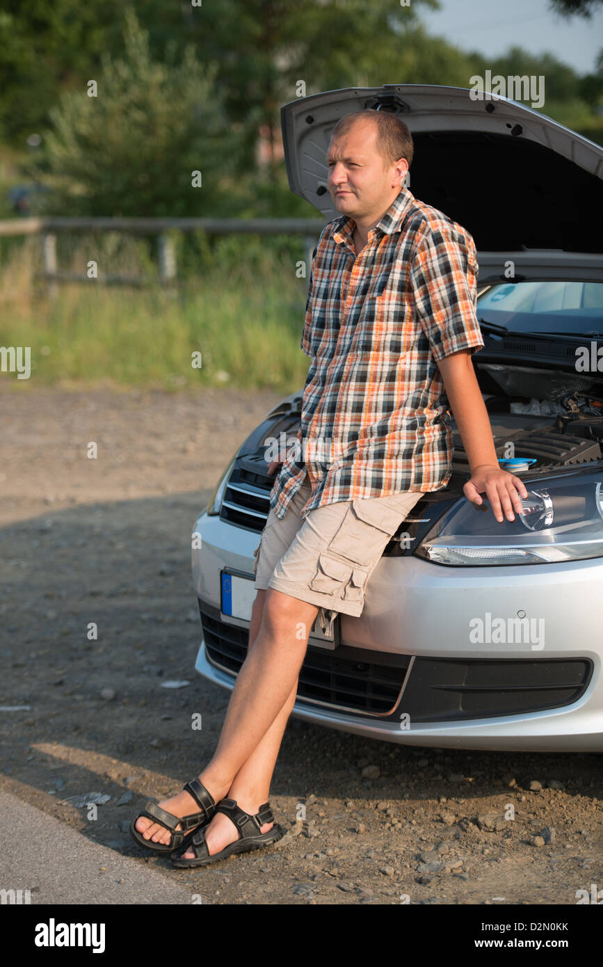 man standing in front of his car with open hood Stock Photo - Alamy
