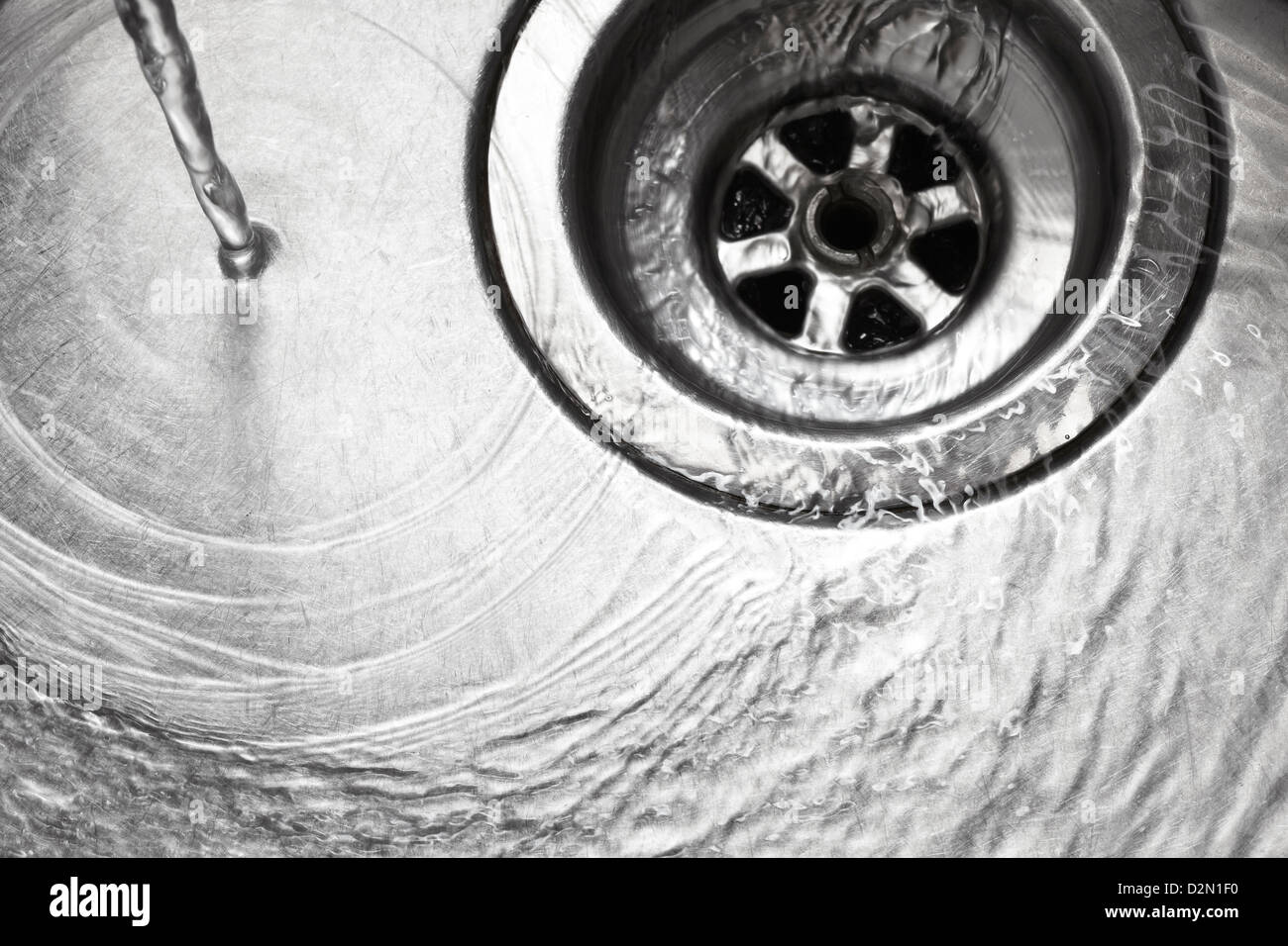 Stainless steel sink plug hole close up with water Stock Photo - Alamy