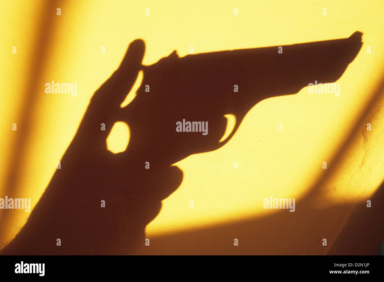 Shadow in warm light of hand in shadows holding pointing and aiming gun ...