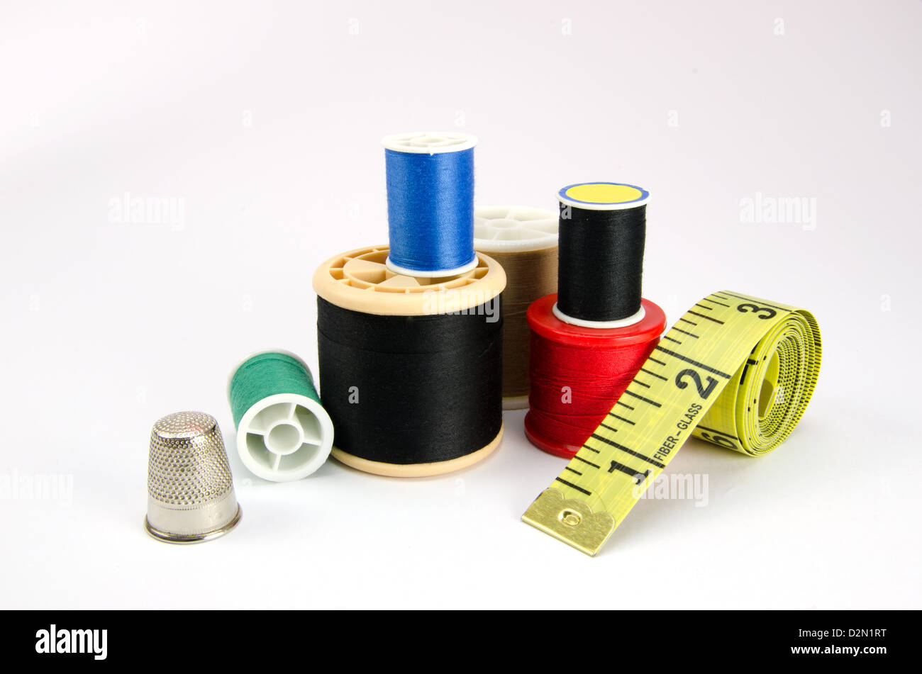 Cotton threads with thimble and tape measure Stock Photo - Alamy