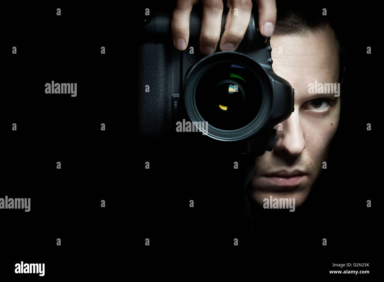 Photographer taking photo with camera on black background Stock Photo ...