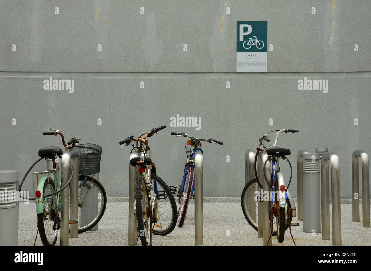 Four cycles - green and blue - parked at a dedicated public bicycle ...