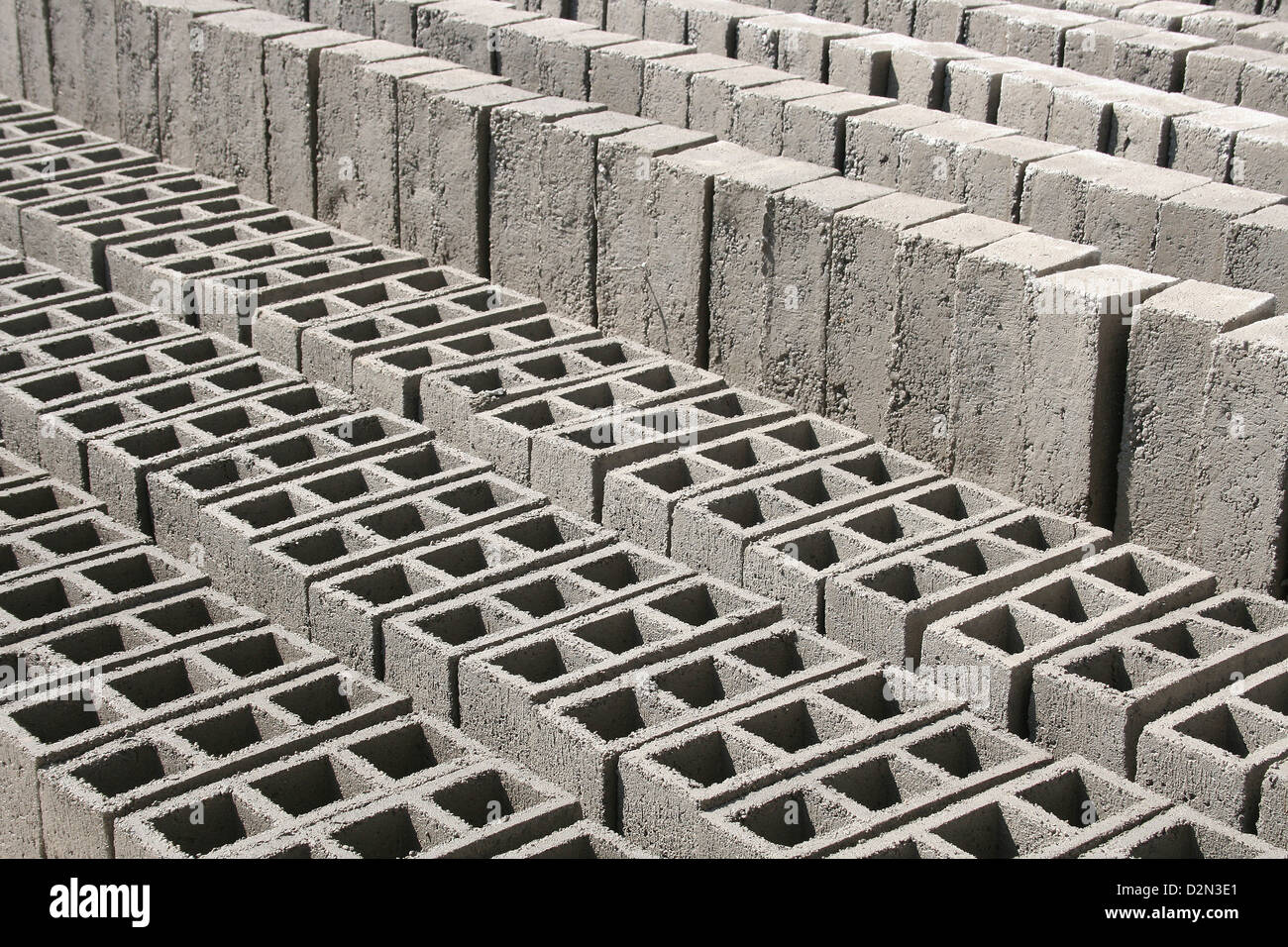 Rows of handmade concrete bricks drying in the sun in a brickyard in ...