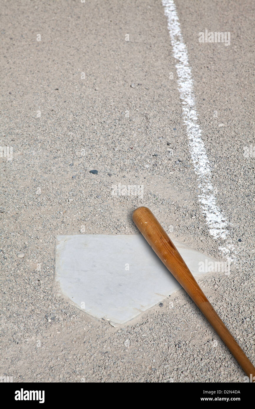 A baseball bat lies across the home plate Stock Photo - Alamy