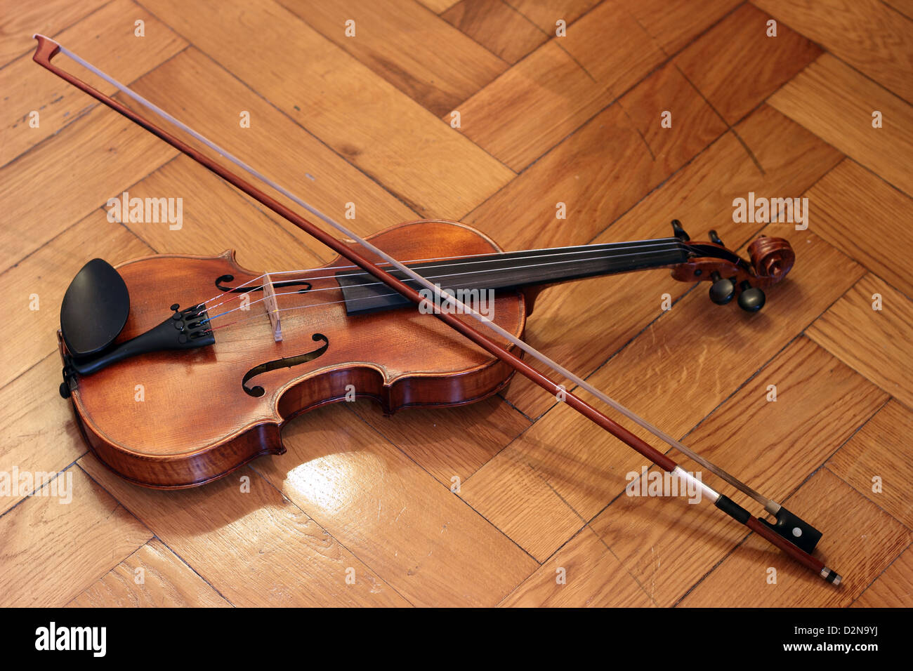Violin and bow on wooden floor Stock Photo - Alamy